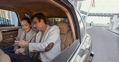 전화 통화를 마치는 동안 차 뒷좌석에서 백인 남성의 손을 잡고 있는 여자 사진 Unsplash의 수송 이미지