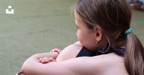 팔짱을 낀 채 바닥에 앉아 있는 어린 소녀 사진 Unsplash의 무료 소녀 이미지