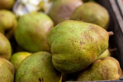 배로 가득 찬 바구니에있는 녹색 배의 클로즈업 초상화 과일은 생물학적으로 재배되어 다른 과일 조각들 사이의 시장 마구간에서 시장에서 판매됩니다 가을에 대한 스톡 사진 및