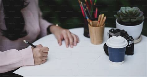 빈 종이에 연필을 들고 뒤뜰에 앉아 있는 젊은 여성의 자른 사진 사진 Unsplash의 태국 이미지