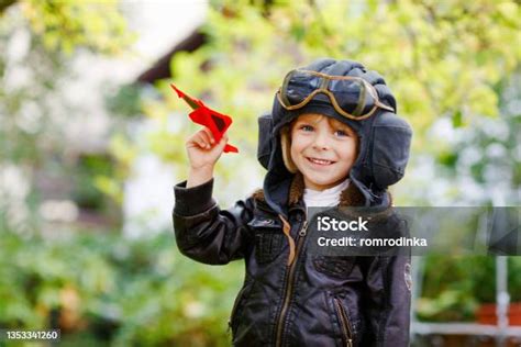 파일럿 헬멧과 빨간색 장난감 비행기와 함께 연주 유니폼에 행복한 어린 아이 소년 웃고 유치원 아이 꿈과 재미 교육 직업 꿈의 개념 파일럿 모자에 대한 스톡 사진 및 기타