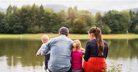 행복한 젊은 가족은 호숫가의 풀밭에 앉아 푸른 자연 속에서 함께 시간을 보내고 있다 후면도 사진 Unsplash의 가족 이미지