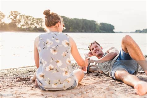 Young Couple Relaxing At The Riverbank Photo Getty Images