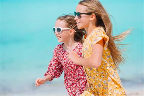 Little Happy Funny Girls Have A Lot Of Fun At Tropical Beach Playing