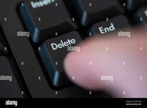 A Macro Closeup Of A Finger Pushing The Delete Button On A Computer