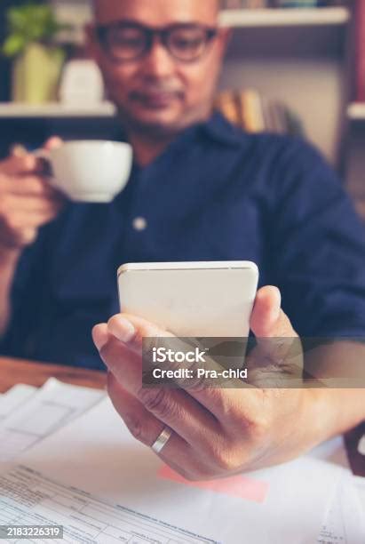 설명 커피 브레이크 동안 스마트폰으로 문서 예산 보고서 및 세금을 포함한 콘텐츠를 검토하는 비즈니스 전문가 책상 세로 이미지 45 49세에 대한 스톡 사진 및 기타 이미지