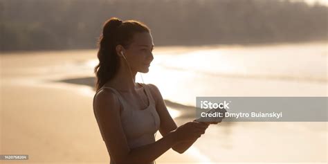 운동복을 입은 건강한 스포츠 여성의 실루엣은 아침에 해변에서 손으로 맥박을 측정합니다 맥박 측정에 대한 스톡 사진 및 기타