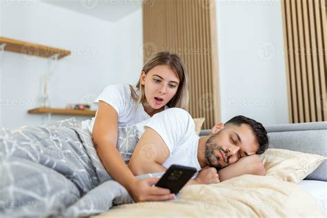 Esposa Celosa Espiando El Teléfono De Su Pareja Mientras él Duerme En