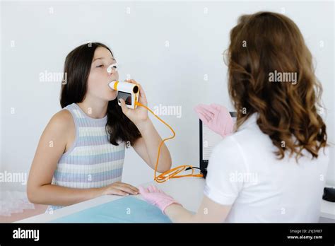 Girl Testing Breathing Function By Spirometry In Doctors Office Diagnosis Of Respiratory