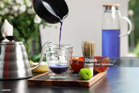 파란색 일치를 만드는 과정입니다 파란색 일치는 유리에 부어 건강한 음식 은 Cocnept 전통 아시아 음료 빛의 정물 채식 건강 음료 음료 말차 다도 관목에 대한 스톡 사진