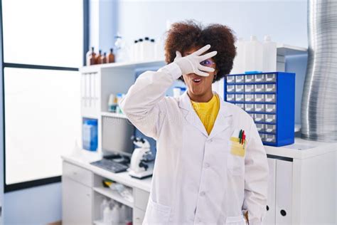 Young African American Woman Working At Scientist Laboratory Peeking In
