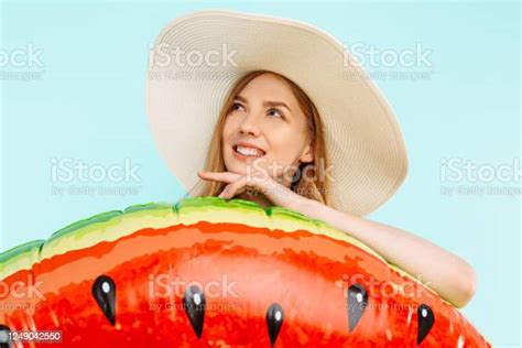 수영복을 입은 여름 모자를 쓴 아름다운 소녀가 고립된 파란색 배경에 풍선 반지를 끼고 서 있습니다 공기 주입에 대한 스톡 사진 및 기타 이미지 Istock