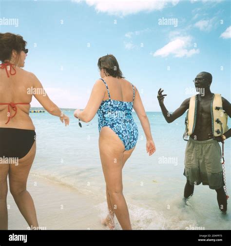 A Black Man Calls Out To Two White Woman At Negril Beach Jamaica Stock