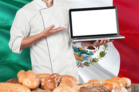 멕시코 국기와 빵 배경에 노트북을 들고 멕시코 베이커 요리사가 복사 공간에 대 한 균일 한 포인팅 빈 화면을 착용 고급 요리에 대한 스톡 사진 및 기타 이미지 Istock