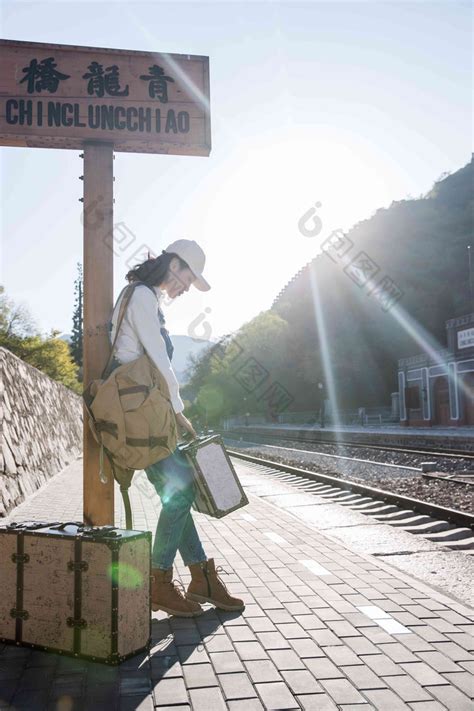 青年女人站在火车站站台上 包图企业站