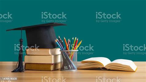 책 더미 위에 놓인 졸업 모자와 그 옆에 연필이 있고 탁자 위에 열린 책이 놓여 있습니다 그것은 교육의 개념입니다 0명에 대한 스톡 사진 및 기타 이미지 Istock