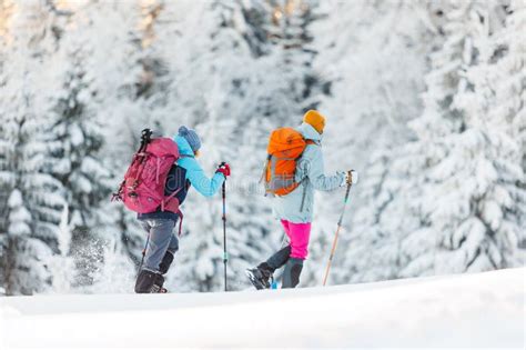 Winter Activity Two Women Walking In Snowshoes In The Snow Winter