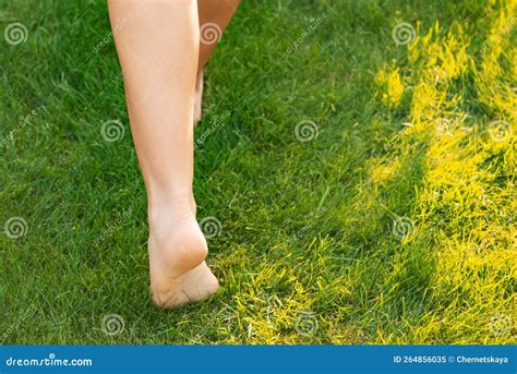Teenage Girl Walking Barefoot On Green Grass Outdoors Closeup Space