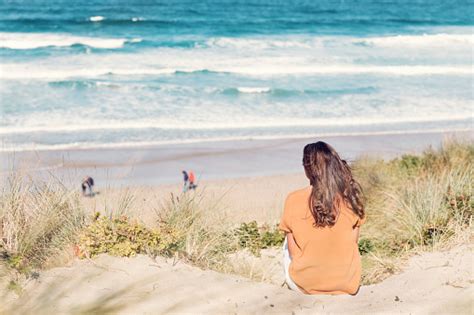 여자는 밝은 화창한가 날에 Fistral 비치 뉴 퀘이 콘월 위에 모래 언덕에 앉아 있었다 10월에 대한 스톡 사진 및 기타 이미지 Istock