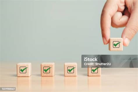나무 블록 체크리스트와 테이블 배경에 손이 있는 녹색 확인 표시 아이콘 비즈니스 작업 서명 약속 일정 개념입니다 올바른 평가 만족도 확인란 기호를 배치하는 사업가 블럭에