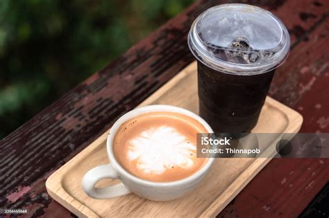 아메리카노 아이스 커피 또는 블랙 커피와 뜨거운 우유 차 안개가 자욱한 숲 아름 다운 풍경 안개 낀 산 자연 배경의 경치 좋은 전망 나무 책상에 컵 0명에 대한 스톡 사진
