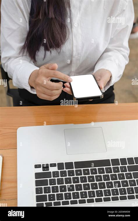 Cropped Sot Of Woman Office Worker Siting In Front Of Laptop Computer And Using Smart Phone