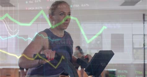 Image Of Data On Graph Over Caucasian Woman Cross Training On Elliptical At Gym Stock Photo