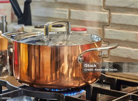 접시가 달린 뚜껑이 달린 구리 냄비는 가스 렌지에서 불로 요리됩니다 냄비 위로 증기가 올라갑니다 요리하기 음식 준비에 대한 스톡 사진 및 기타 이미지 Istock