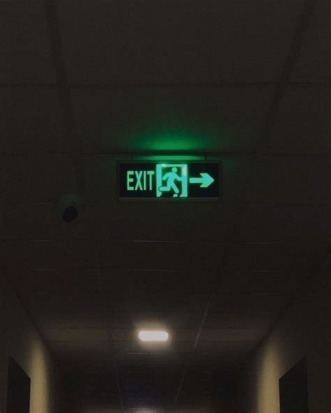 Glowing Exit Sign In Dark Hallway