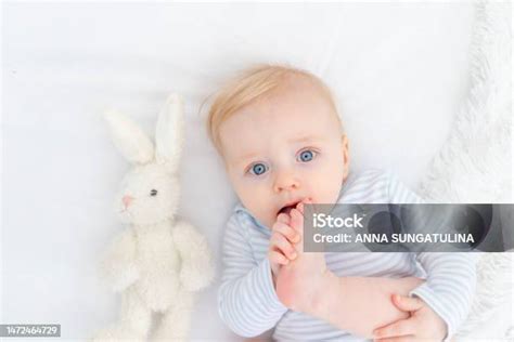 Photo Libre De Droit De Portrait Dun Bébé Qui Suce Un Pied Allongé Sur