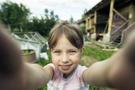 Девочка сидя на деревянной лестнице в деревне Стоковое Фото изображение насчитывающей