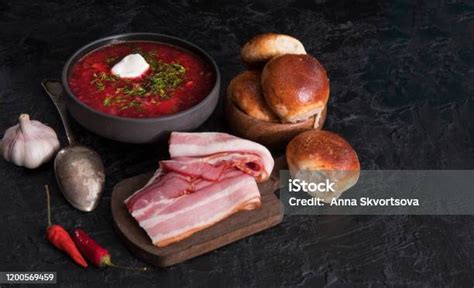 검은 배경에 마늘 빵과 사워 크림주철 냄비에 전통적인 우크라이나어 또는 러시아어 붉은 야채와 고기 수프 Borscht 사탕무