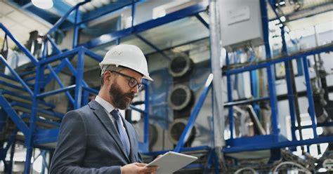 안전모를 쓴 수석 엔지니어가 태블릿을 들고 산업 공장을 걷고 있습니다 사진 Unsplash의 공학자 이미지