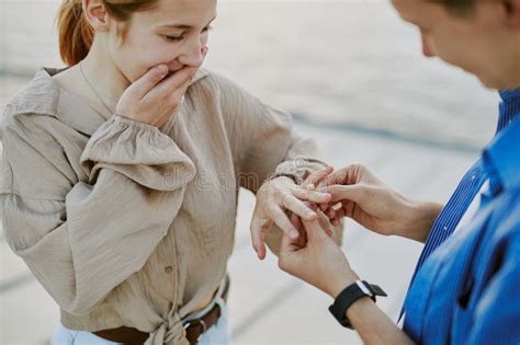 Woman Receiving Engagement Ring By Waterfront Setting Stock Image