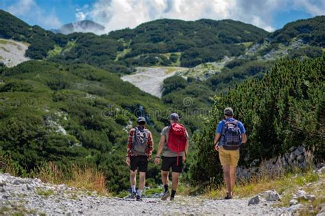 Three Adventurous Individuals Exploring A Nature Trail In Triglav