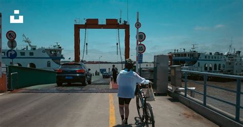 자동차와 보트를 배경으로 다리에서 자전거를 타는 사람 사진 Unsplash의 무료 사람의 이미지