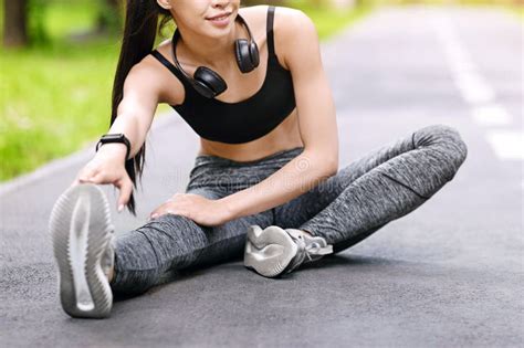 Young Asian Girl Stretching Legs Before Jogging Outdoors Warming Up