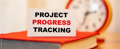 PROJECT PROGRESS TRACKING Is Written On A Document With A Time Background And On A Red Folder