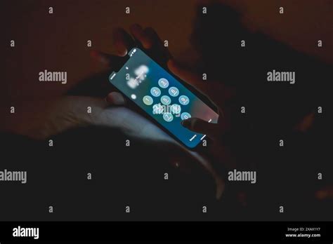 A Person Entering A Pass Code On A Smart Phone Screen In A Dimly Lit