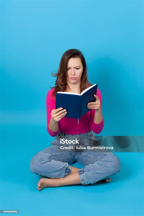 전체 길이의 젊은 여성이 바닥에 앉아 파란색 배경에 고립 된 열린 일기에 깜짝 놀란 모습 경영자에 대한 스톡 사진 및 기타 이미지 경영자 계획 교육 Istock