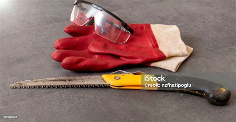 작업 안전을 위해 장갑을 끼고 작업할 필요가 있으며 바닥에는 손 톱과 두꺼운 플라스틱 장갑이 있습니다 날에 대한 스톡 사진 및