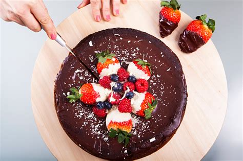 딸기 블랙베리 블루베리로 초콜릿 치즈케이크를 자르는 여성 라즈베리에 대한 스톡 사진 및 기타 이미지 라즈베리 초콜릿 케이크 Istock