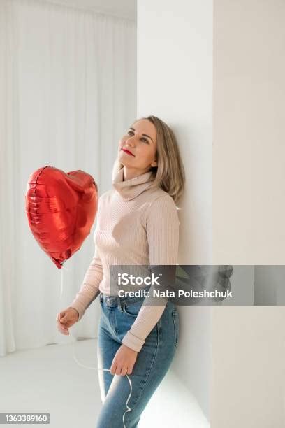 소녀는 하얀 벽에 구름을 하고 미소를 지으며 붉은 하트 모양의 풍선을 들고 있다 해피 발렌타인 데이 2월에 대한 스톡 사진 및 기타 이미지 Istock
