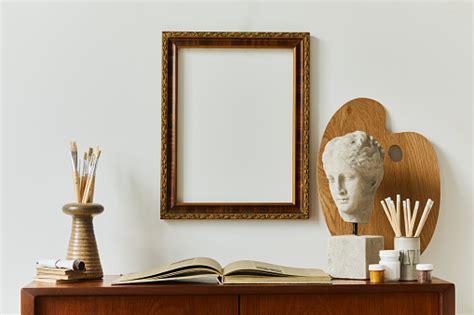 디자인 복고풍 티크 컴모드 모의 포스터 프레임 책 장식 및 페인팅 액세서리와 예술가 작업 공간의 세련된 구성 템플릿 예술에 대한