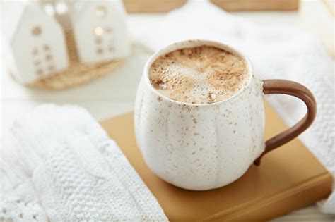 가을 작곡 뜨거운 커피 한 잔 양초 촛대 미니어처 하우스 나무 테이블에 따뜻한 스웨터 계절에 맞는 모닝 핫 커피 휴식과 정물