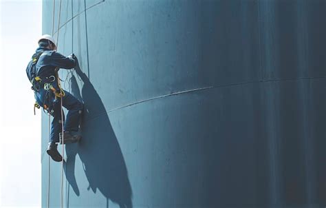 두께 저장 오일 및 가스 탱크 산업의 남성 작업자 로프 접근 높이 안전 검사 프리미엄 사진