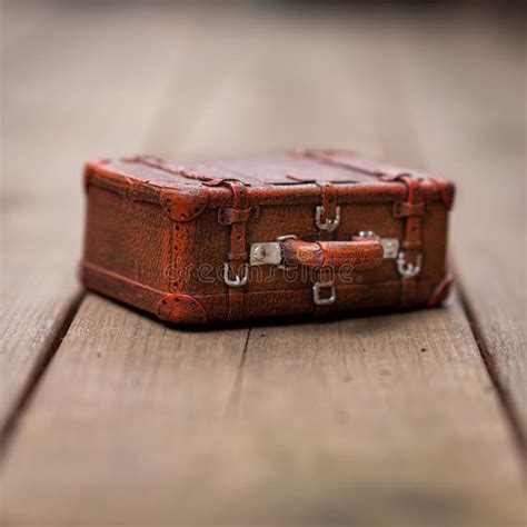 Close Up Shot Of A Tiny Decorative Leather Suitcase On A Wooden Surface
