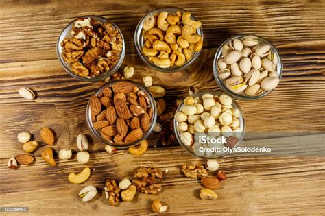 나무 테이블에 견과류의 구색 아몬드 헤이즐넛 피스타치오 호두 캐슈를 유리 그릇에 담습니다 맨 위 보기 건강한 식생활 개념 0명에 대한 스톡 사진 및 기타 이미지 Istock