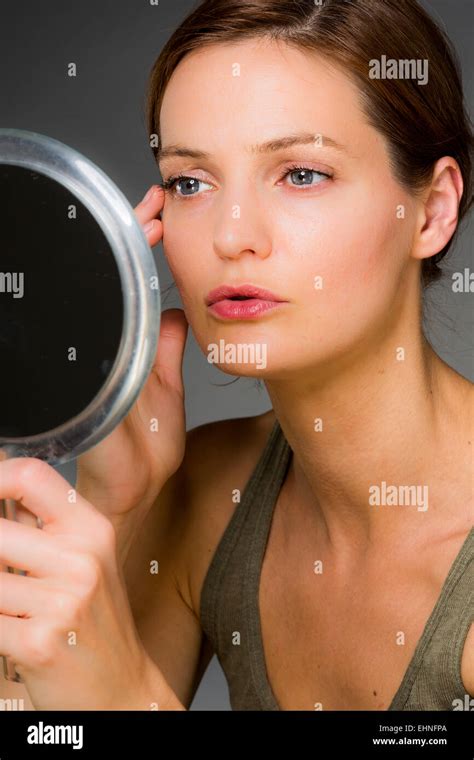 Woman Checking Her Face In The Mirror Stock Photo Alamy