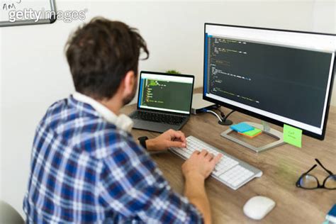 hispanic programmer typing and writing a new code on the computer while working at the office